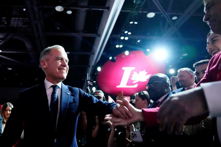 A photo of Mark Carney smiling and greeting supporters and clasping the ...
