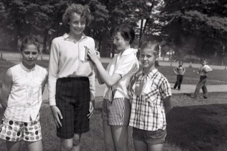 A black and white photo shows four school-aged girls posing for the ...