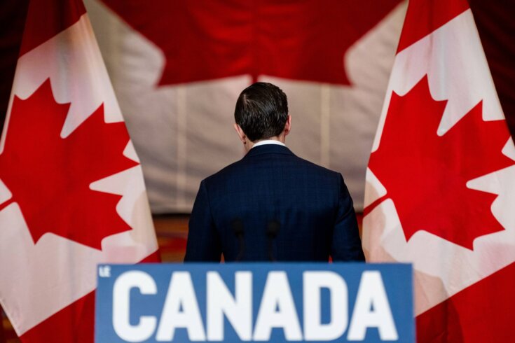 The back of a suited political candidate behind a podium that says ...